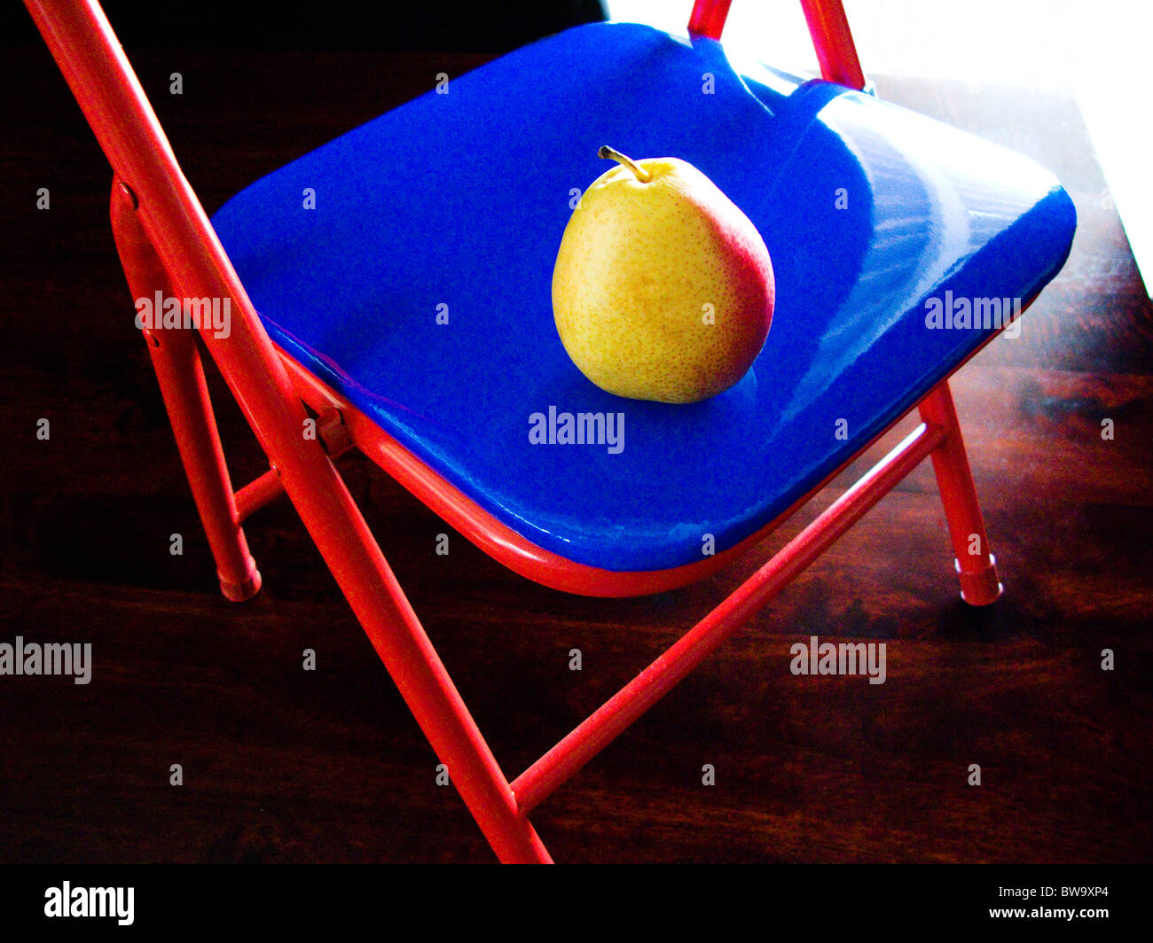 pear sitting on red and blue chair Stock Photo - Alamy