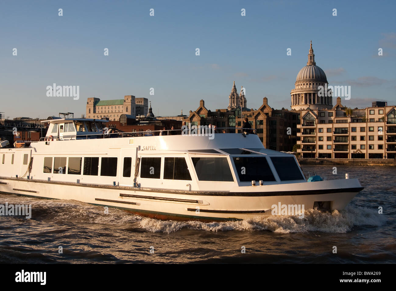 A tourist river boat on the river Thames in London; Saint Paul's ...