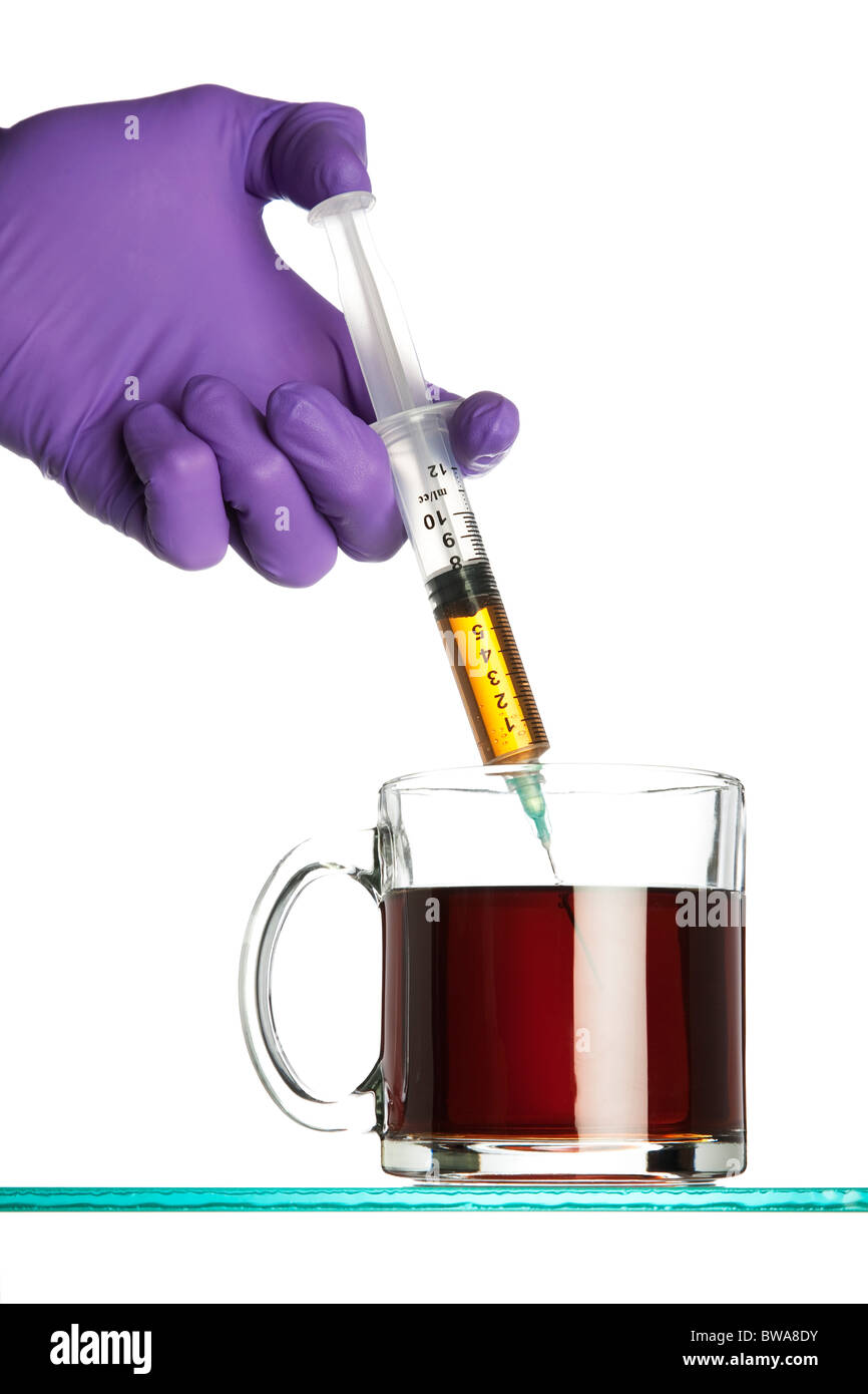 Hand holding syringe, injecting into a coffee cup Stock Photo - Alamy