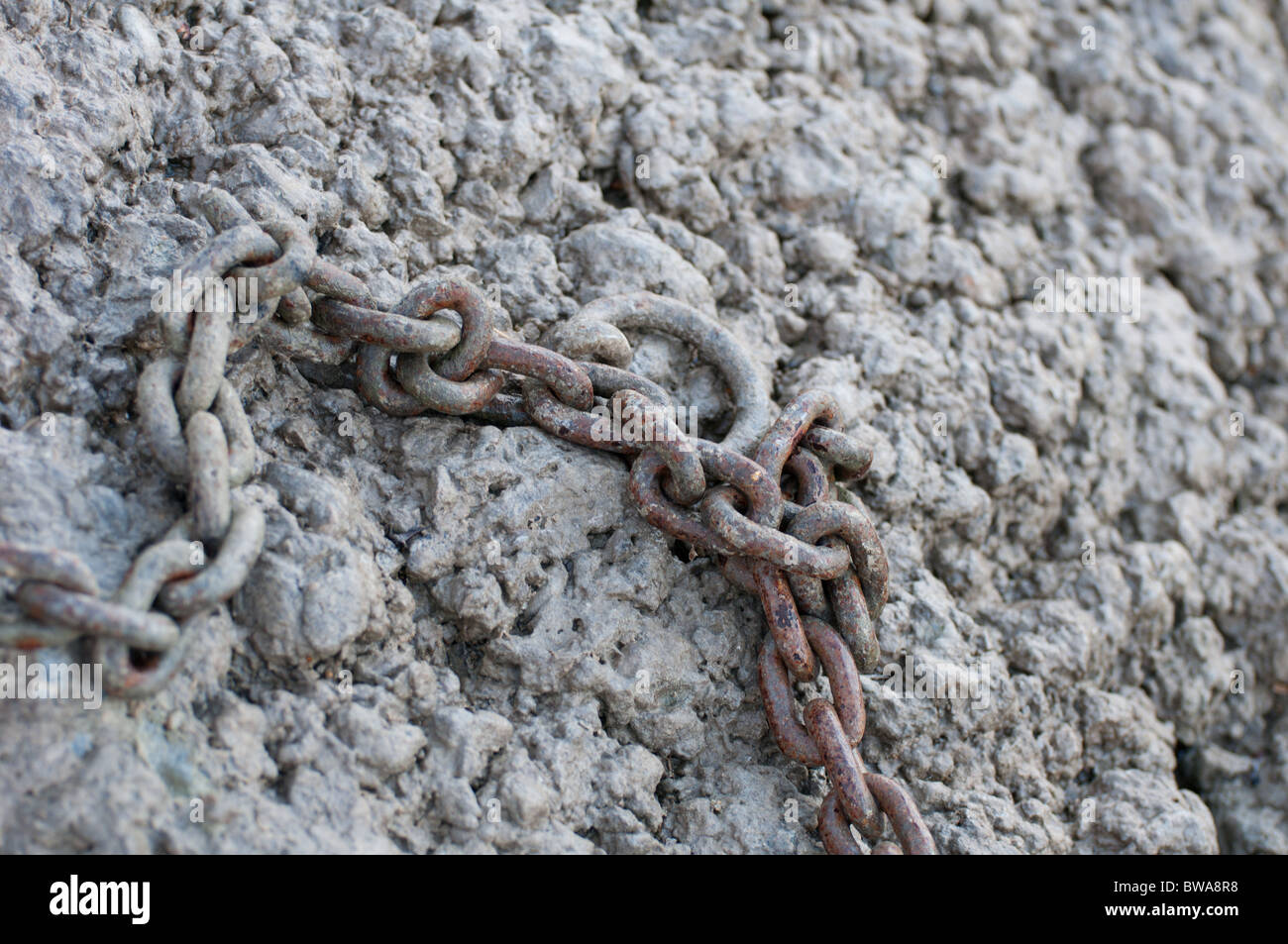Chain on rock Stock Photo - Alamy