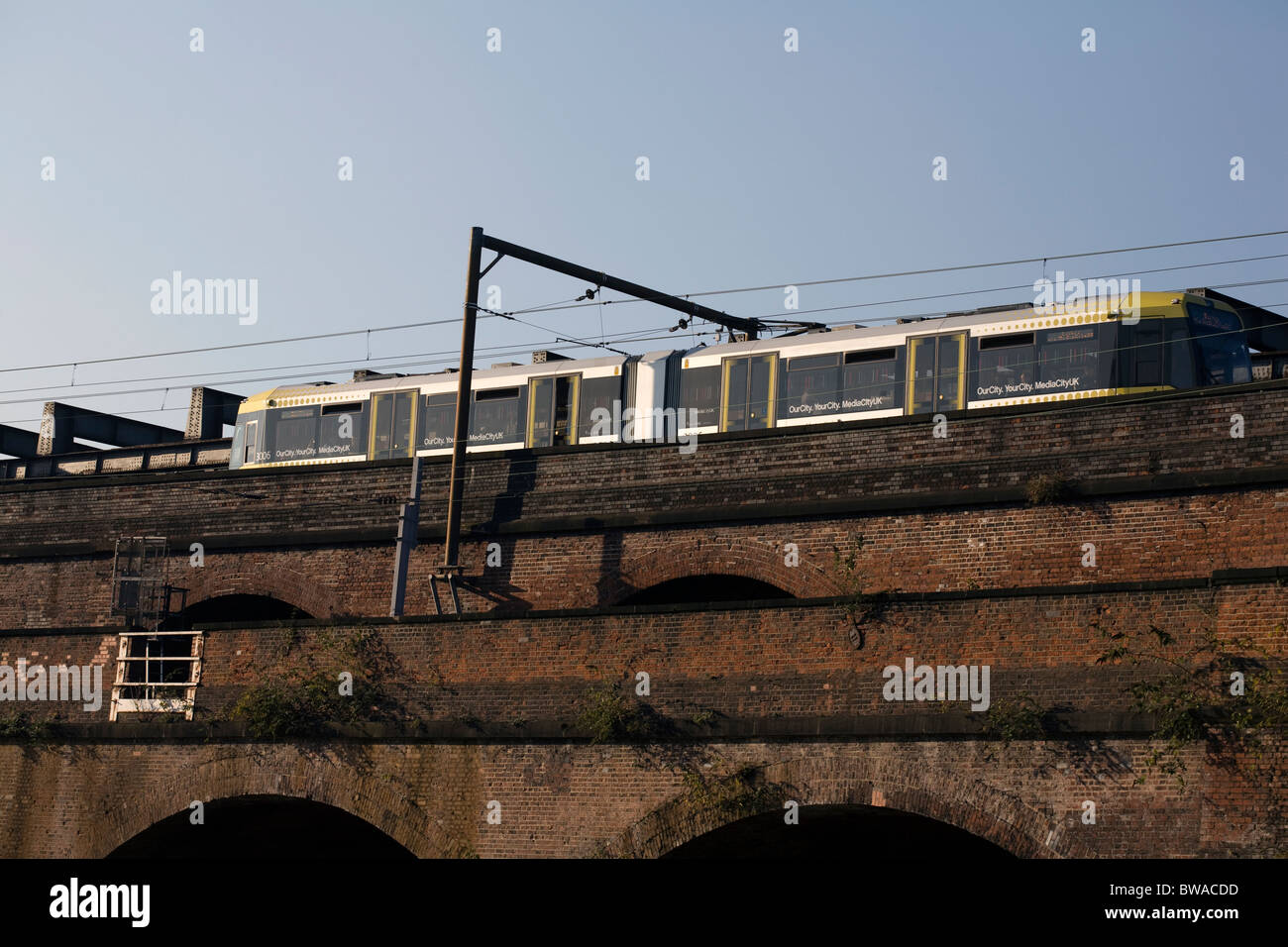 Tram crossing viaduct above Castlefield Canal Basin Manchester England ...
