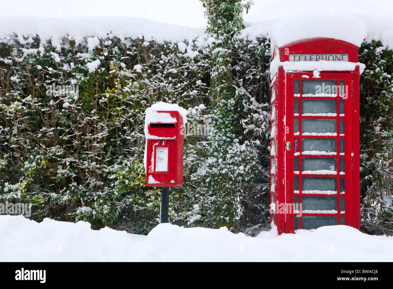 A traditional red English public phone and post box after a heavy snow ...