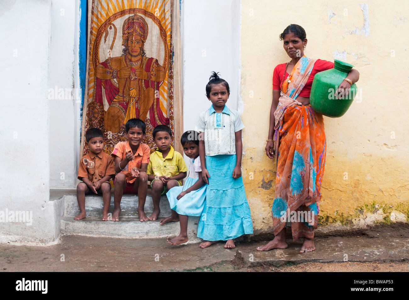 Indian village boys and girls sat outside a house with a mother ...