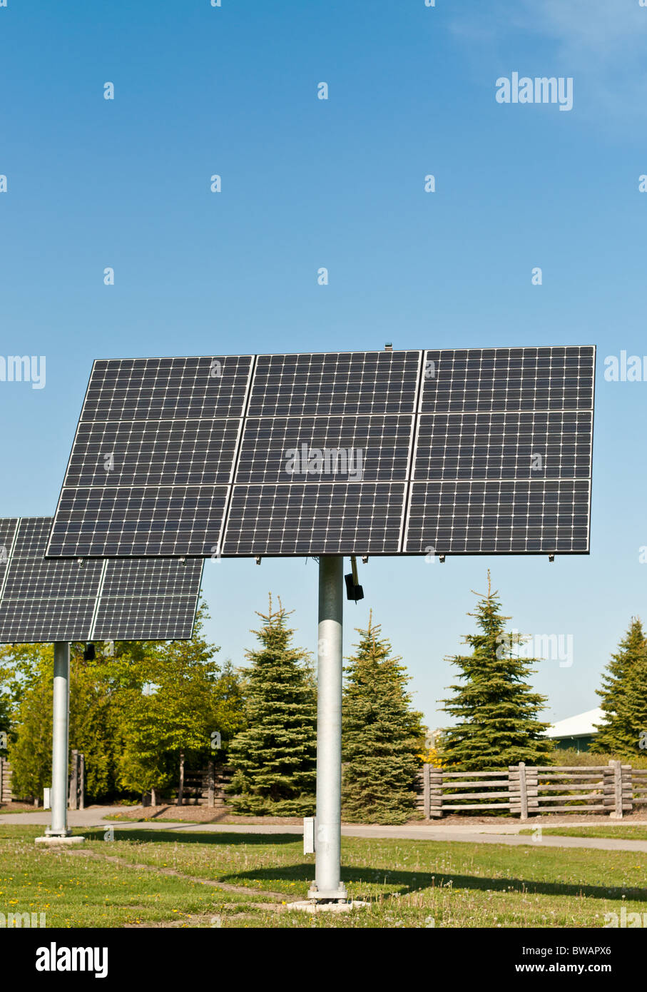 Two arrays of photovoltaic solar panels stand in the grass in a public ...