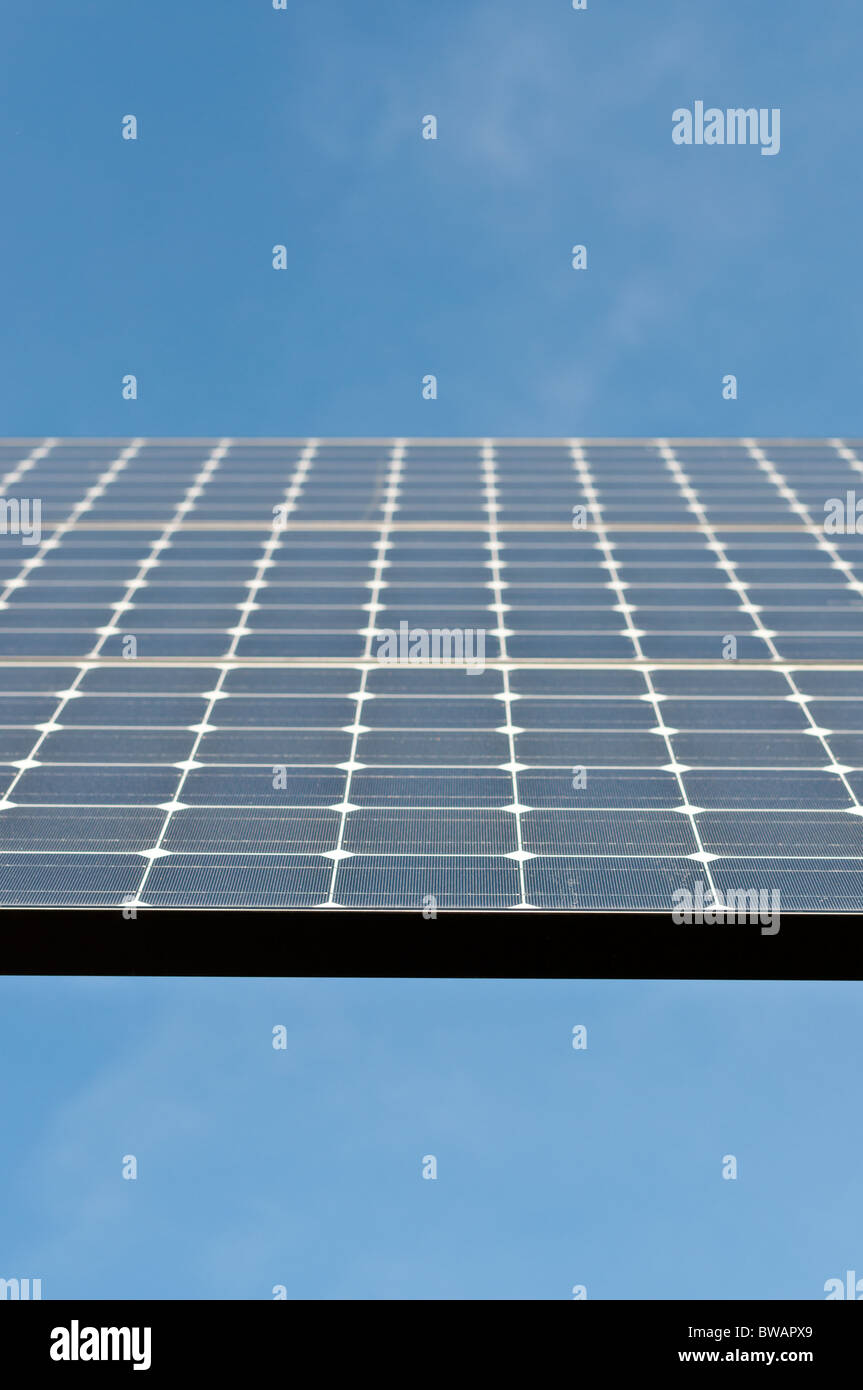 Two arrays of photovoltaic solar panels stand in the grass in a public ...