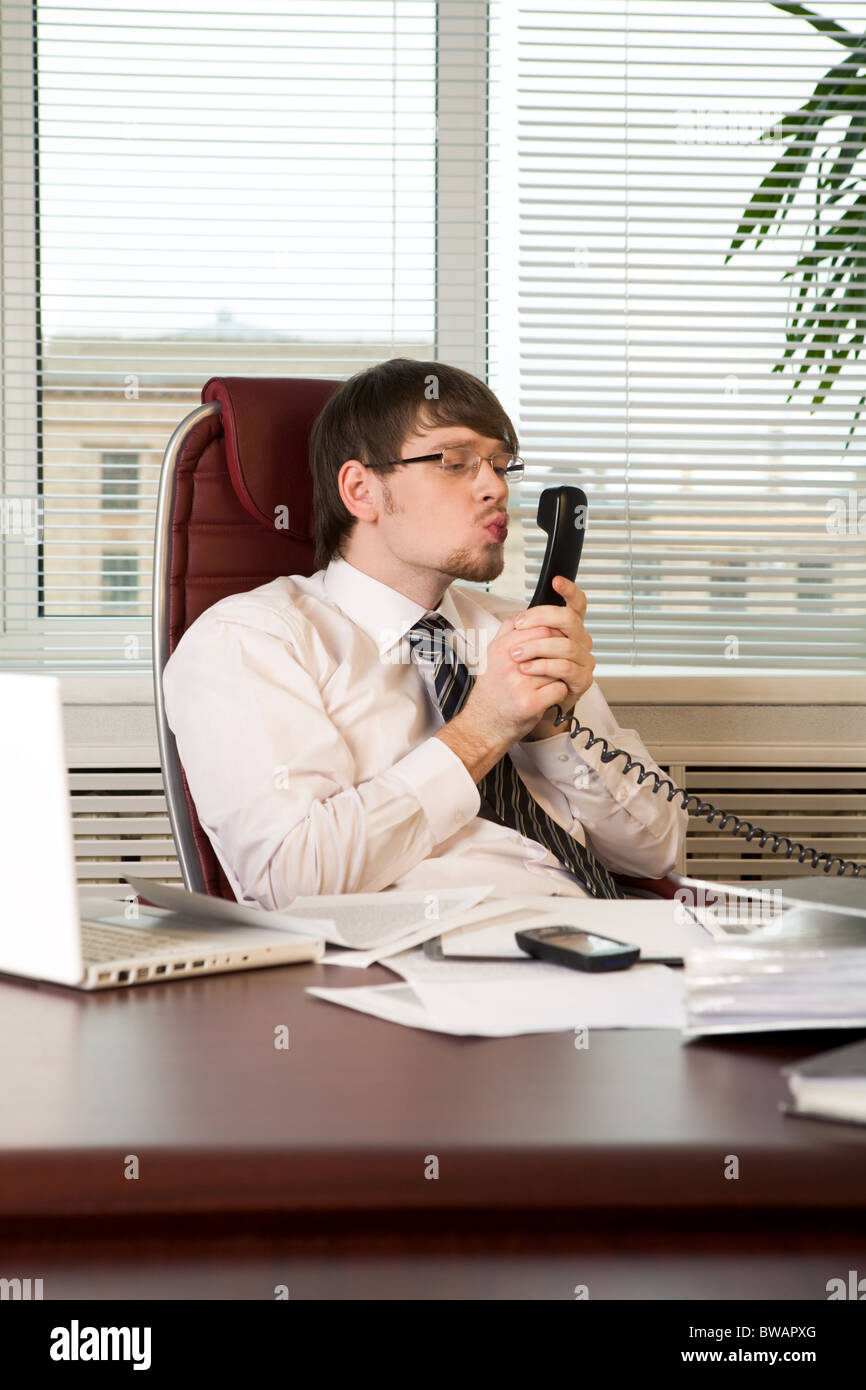 Portrait of ironic businessman giving an air kiss to his secretary into ...