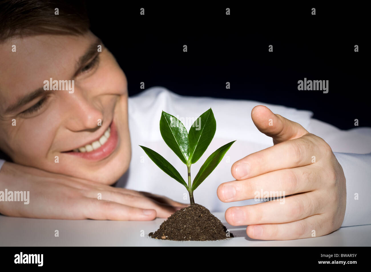 Image of man observing cultivation of a young plant Stock Photo - Alamy