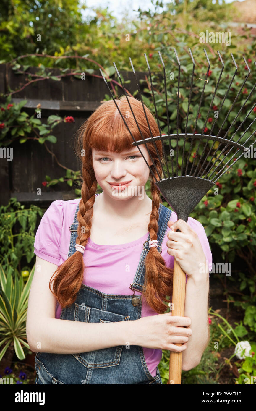 Woman holding grass rake in garden Stock Photo - Alamy