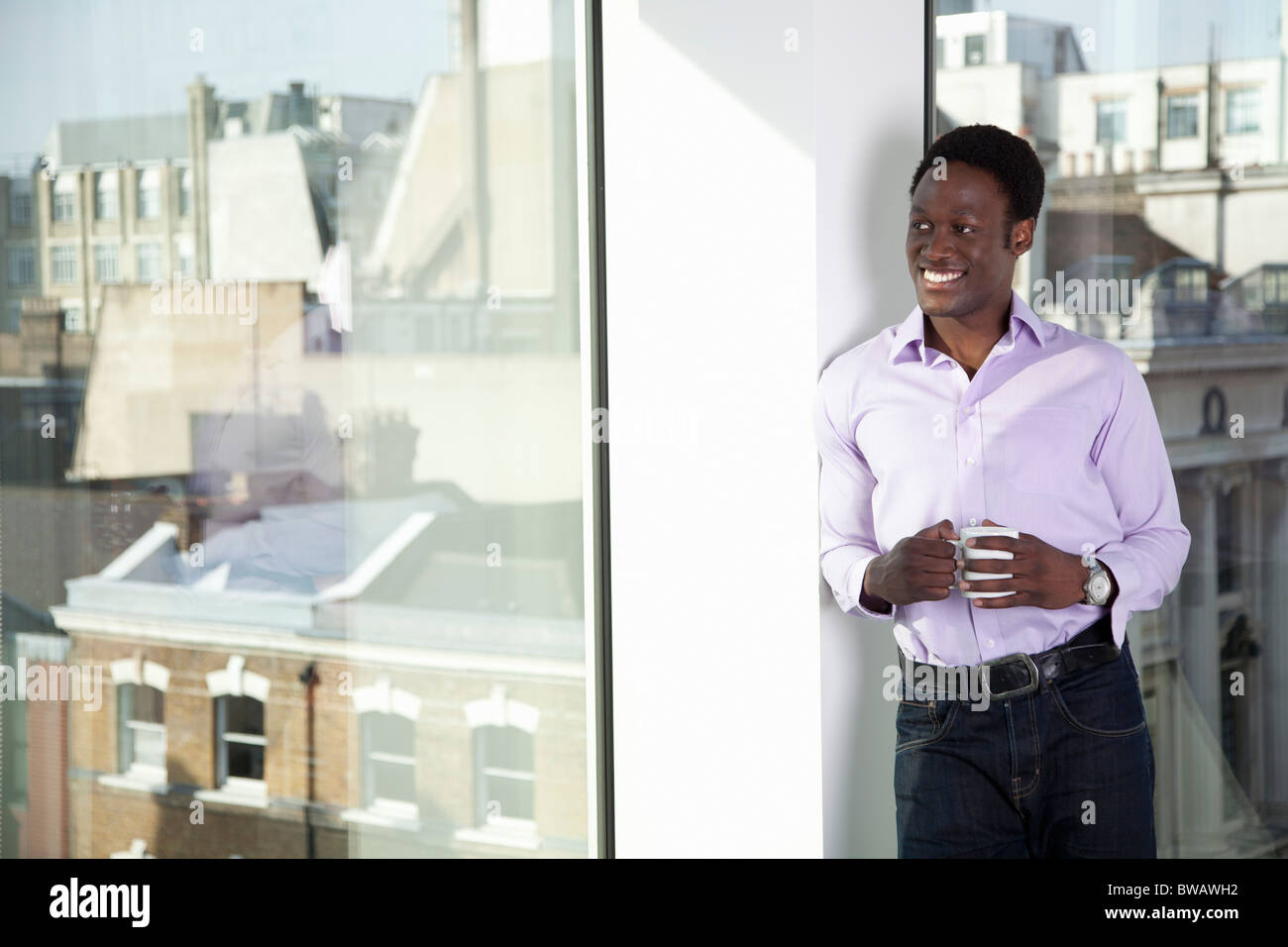 Businessman looking out of office window Stock Photo - Alamy