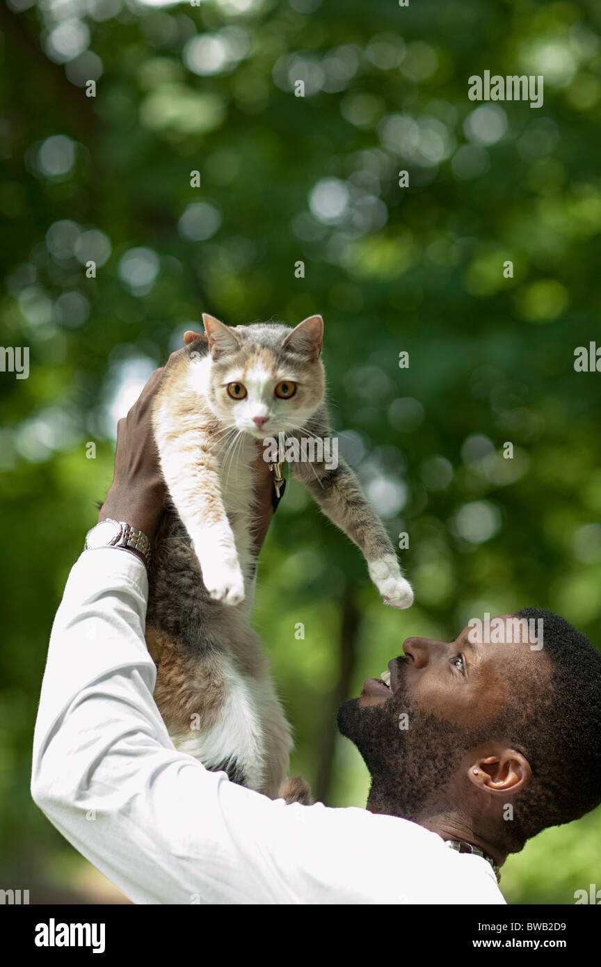 Man lifting a cat up Stock Photo - Alamy