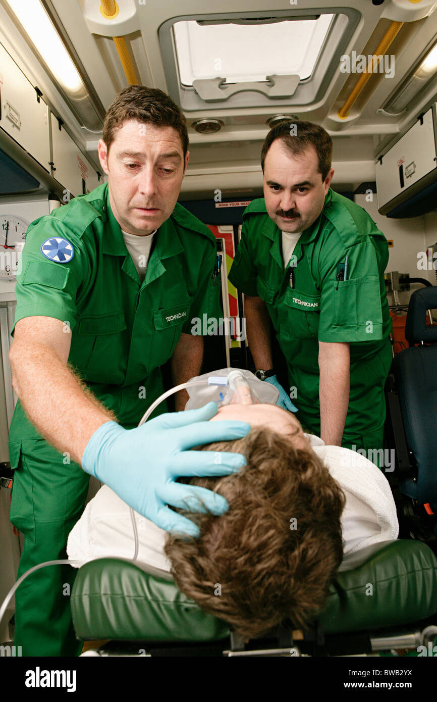Ambulance technicians caring for patient Stock Photo - Alamy
