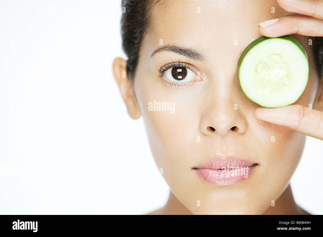 Woman holding cucumber over eye Stock Photo - Alamy