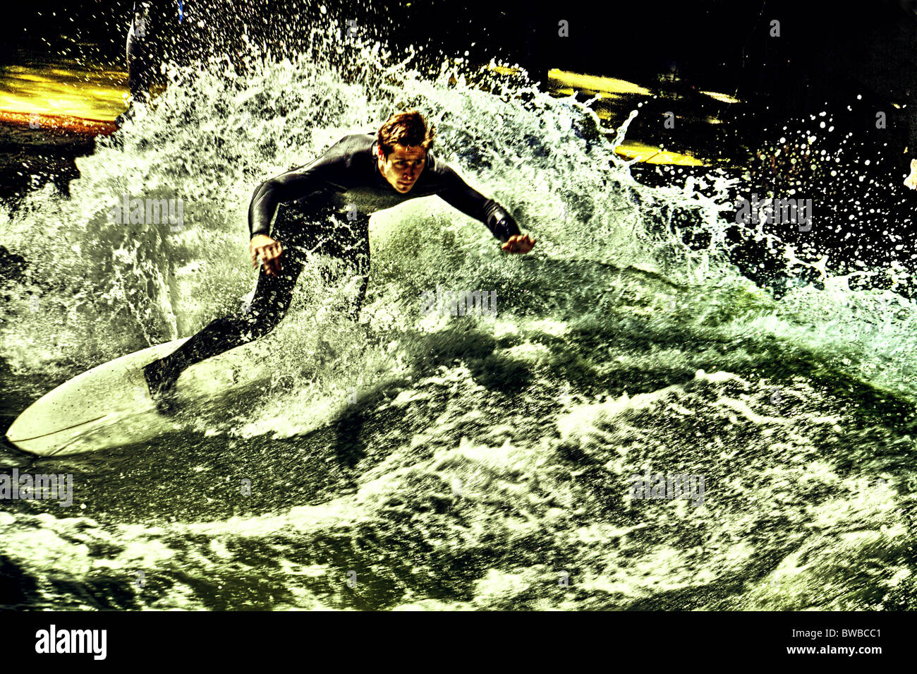 Surfing on Isar river, on the Eisbach wave, near the Haus der Kunst , a ...