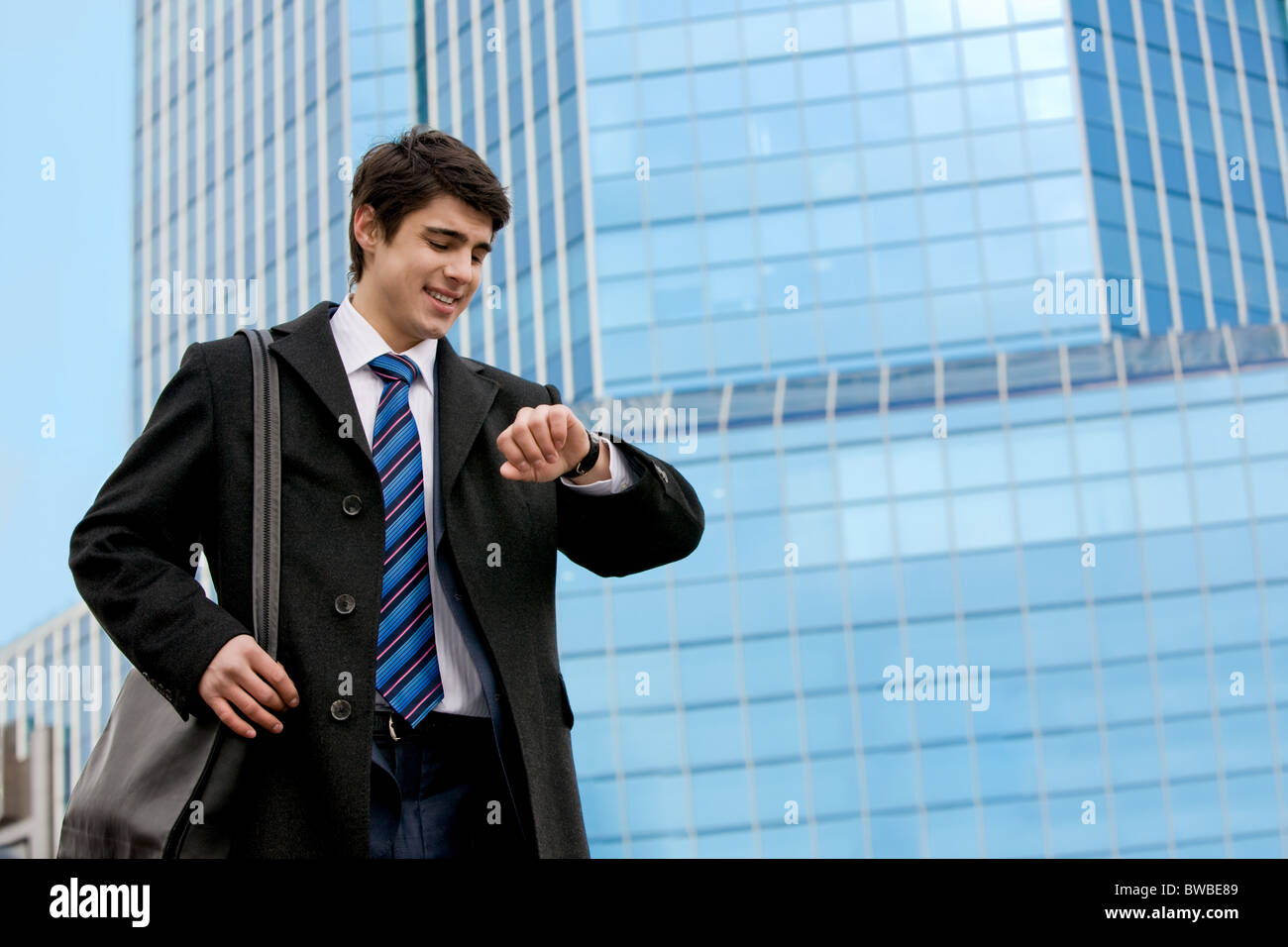 Portrait of smart businessman watching the time while waiting for the ...