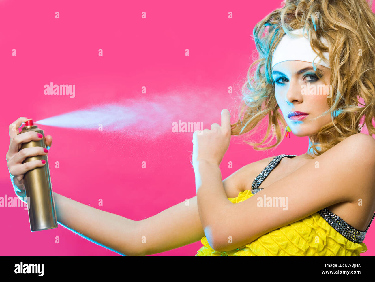 Photo of gorgeous female spraying hair lacquer onto her curlers Stock ...