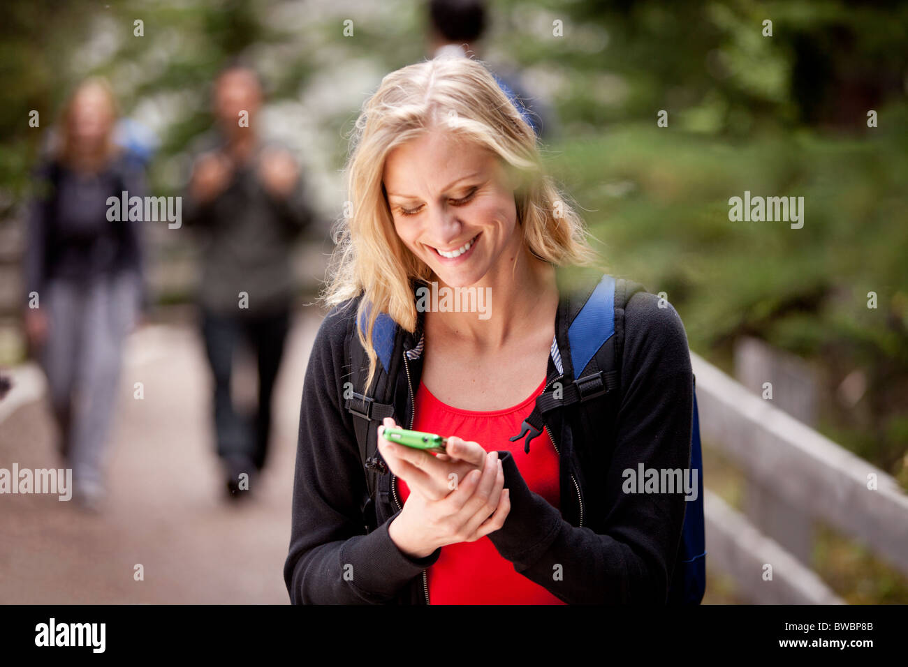 A young woman reading a friendly text while outdoors Stock Photo - Alamy