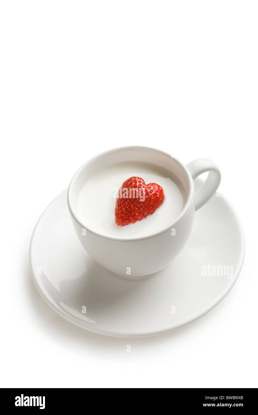 Image of red ripe strawberry heart inside cup of milk over white ...