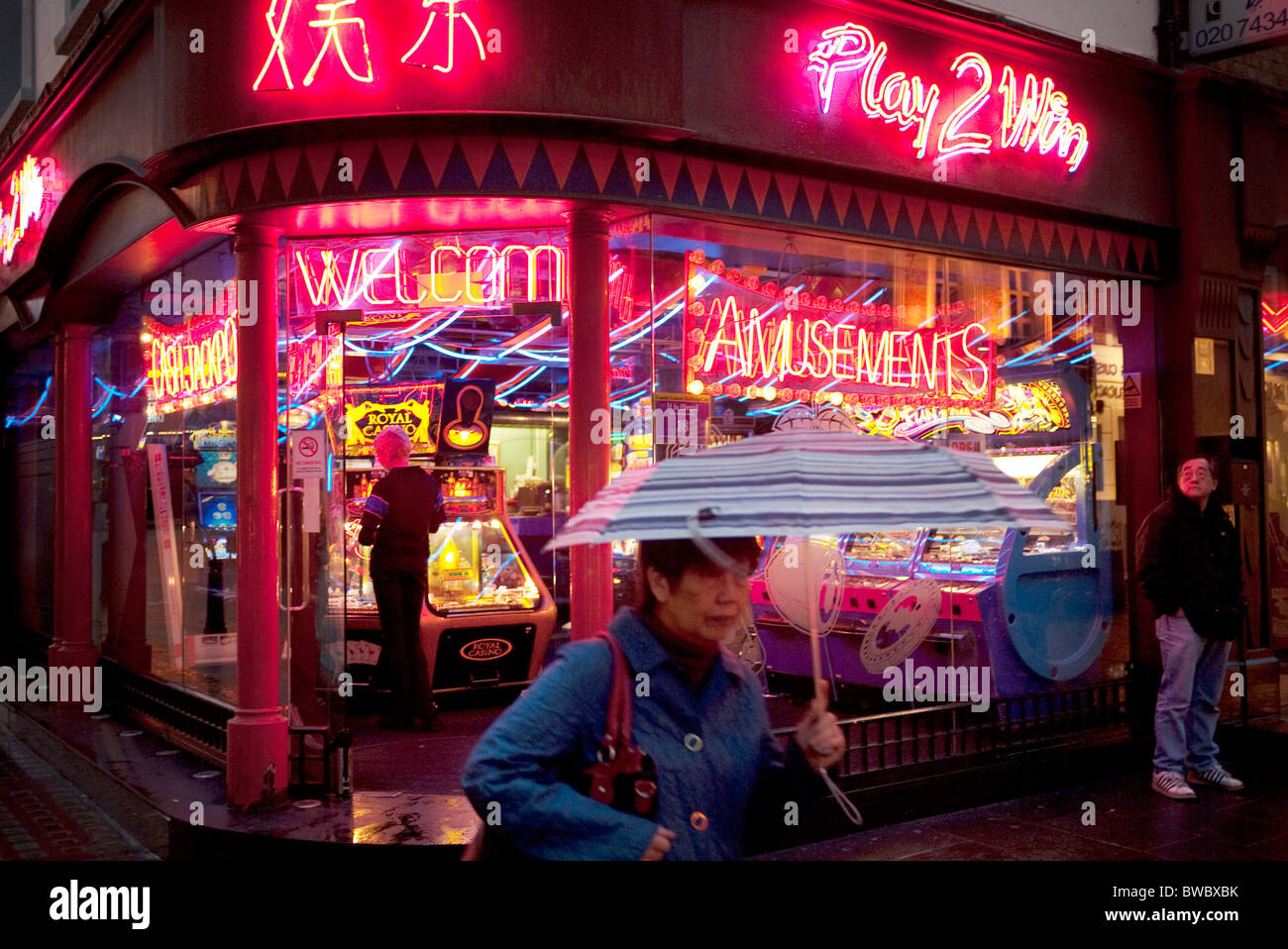 Night time scene outside an amusements arcade in Chinatown. Here people ...