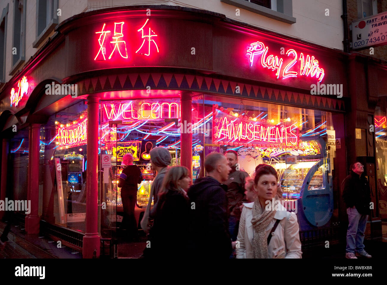 Night time scene outside an amusements arcade in Chinatown. Here people ...