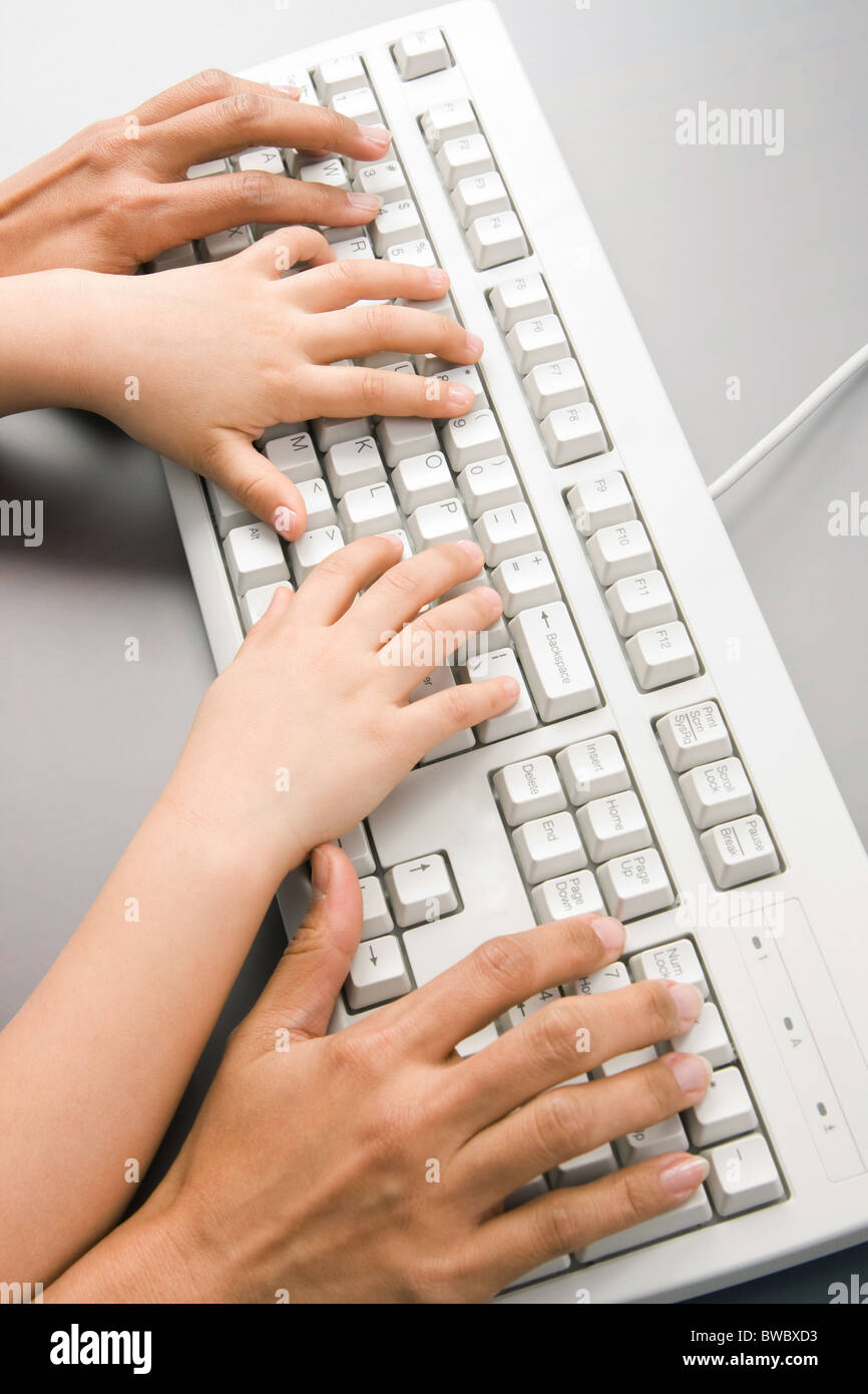 Close-up of female and her child hands over keyboard of computer Stock ...