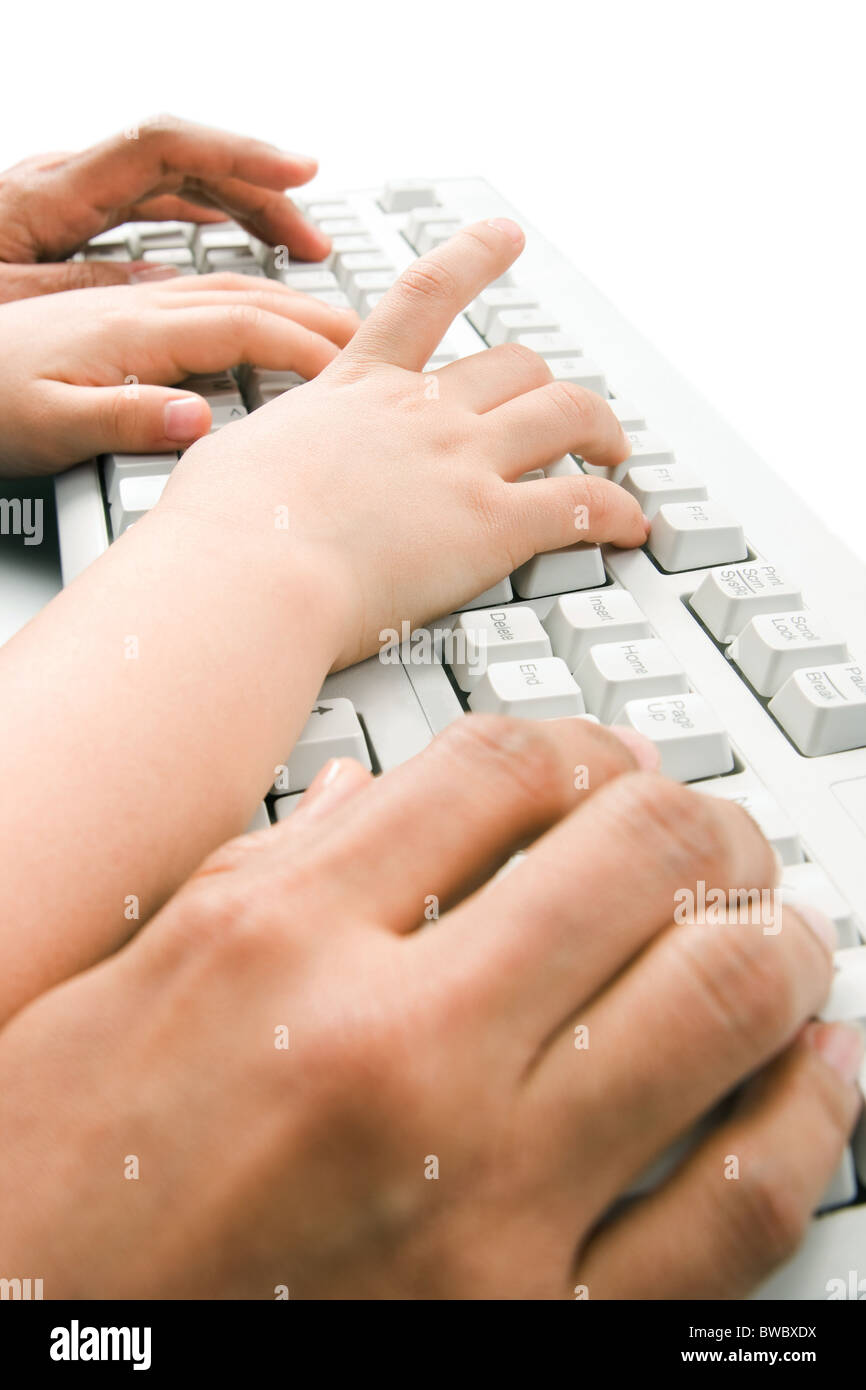 Close-up of female and her child hands over keyboard learning to type ...