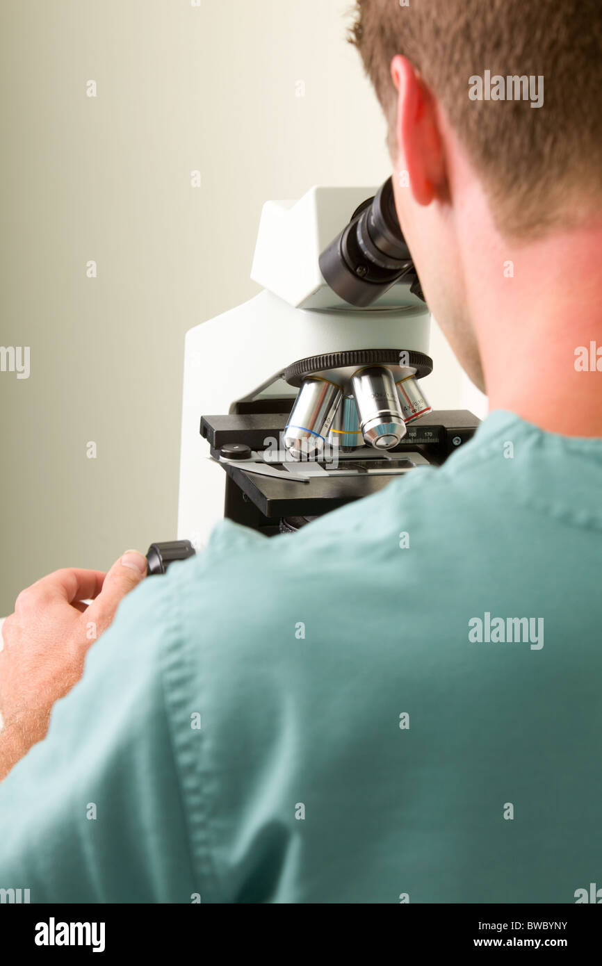 A man looking through a microscope Stock Photo - Alamy
