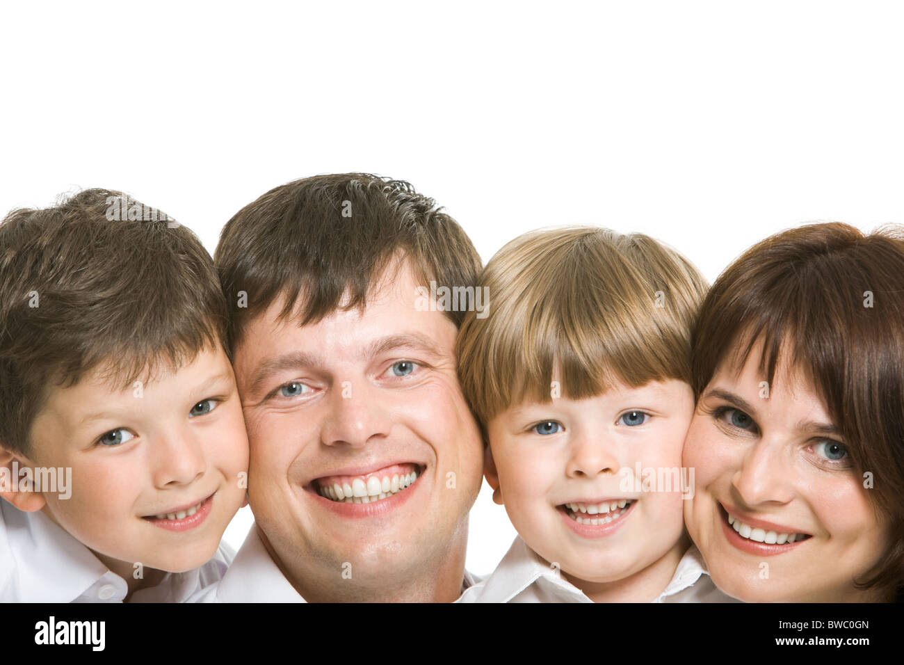 Faces of four family members looking at camera with happy smiles on ...