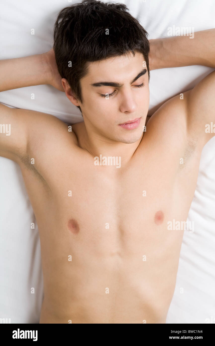 Photo of sleeping young man with his hands under head Stock Photo - Alamy