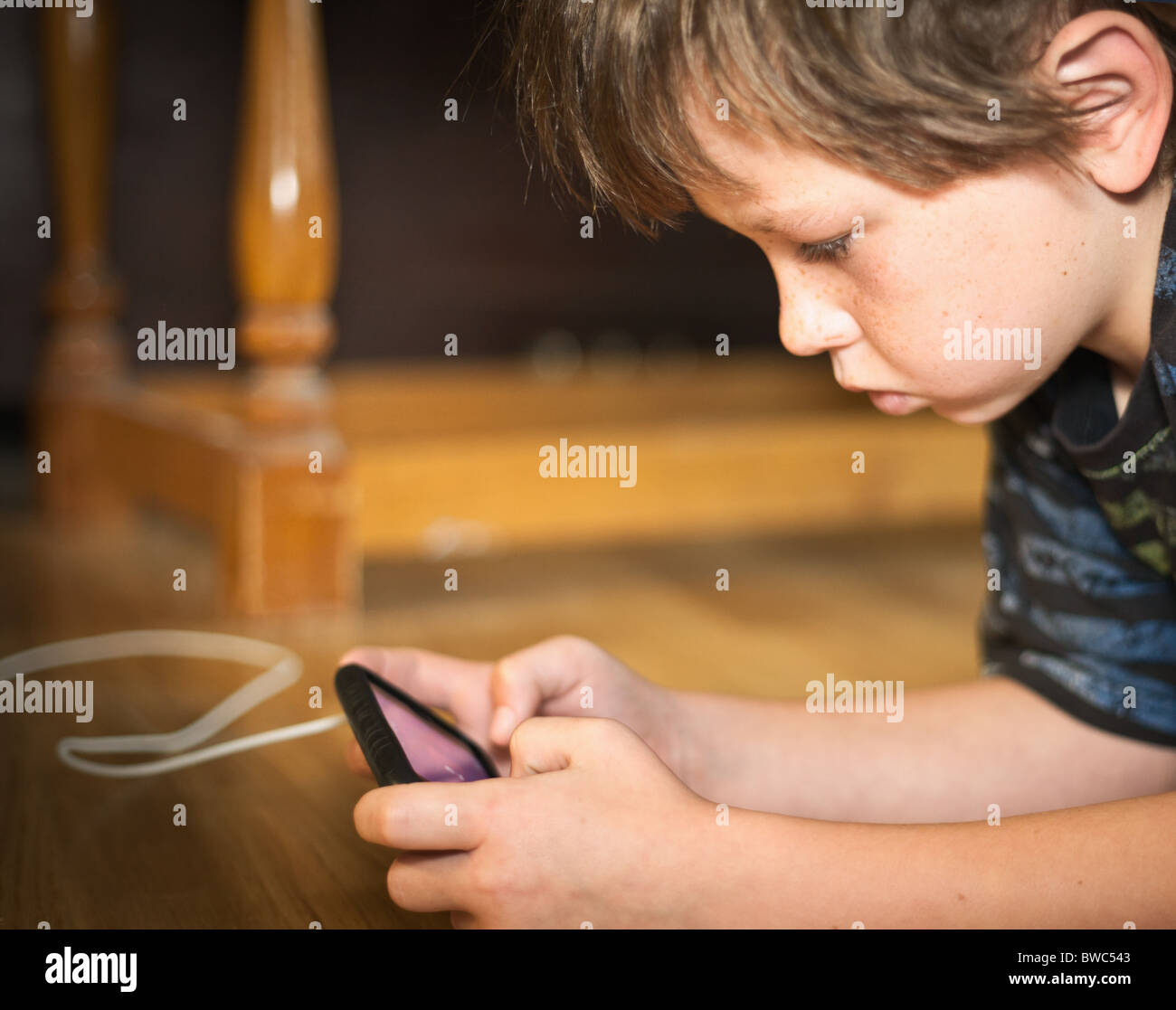 Boy portable gaming on floor Stock Photo - Alamy