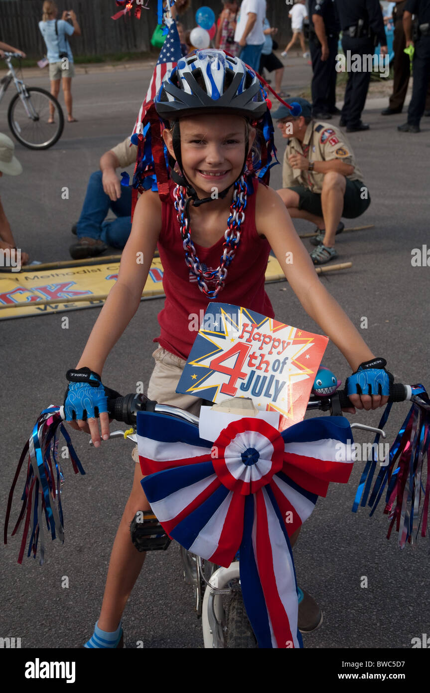 Young Anglo girl rides her decorated bicycle during neighborhood Fourth ...