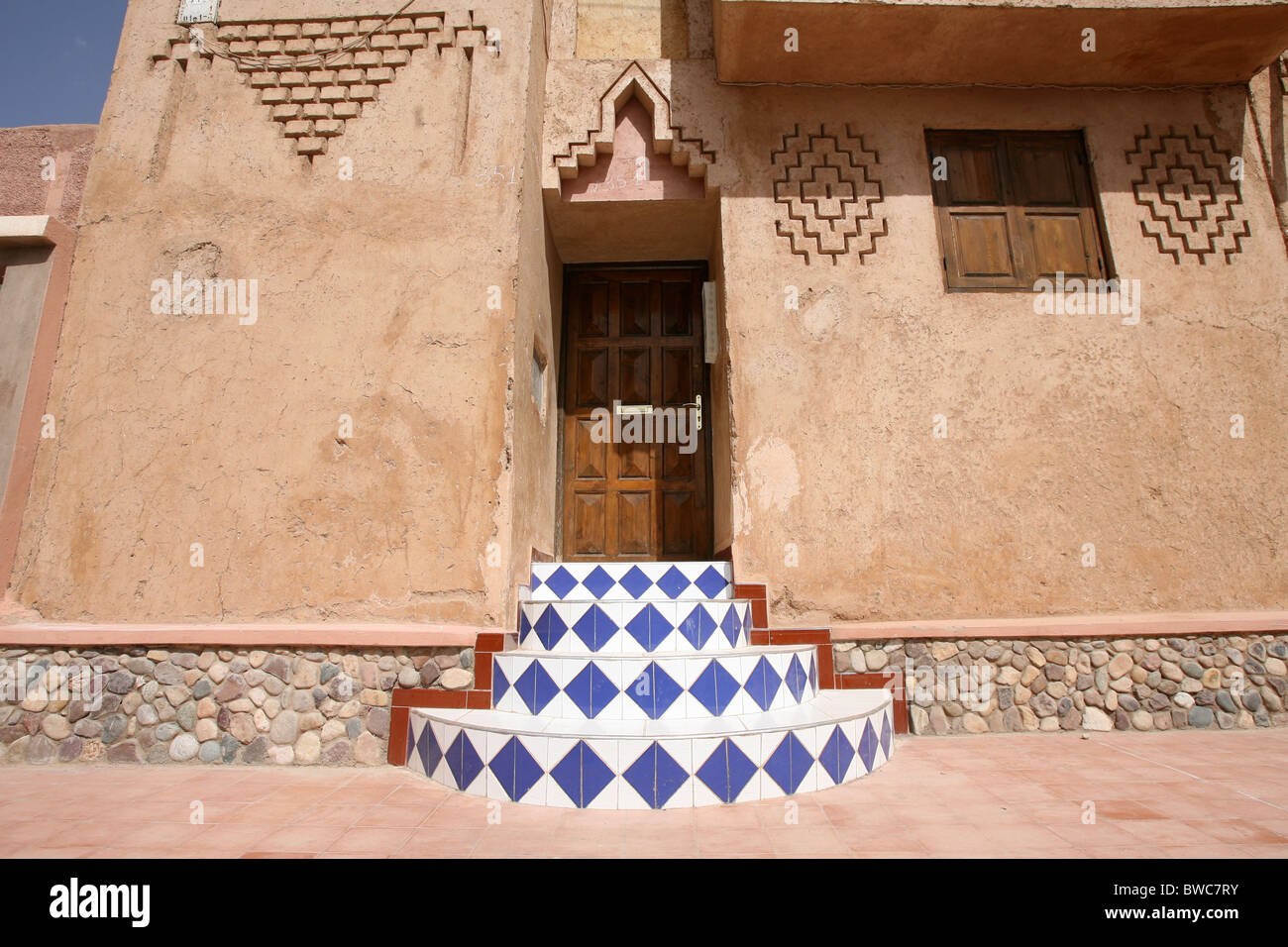 Coloured tiled steps leading to a wooden doorway in a moroccan town ...