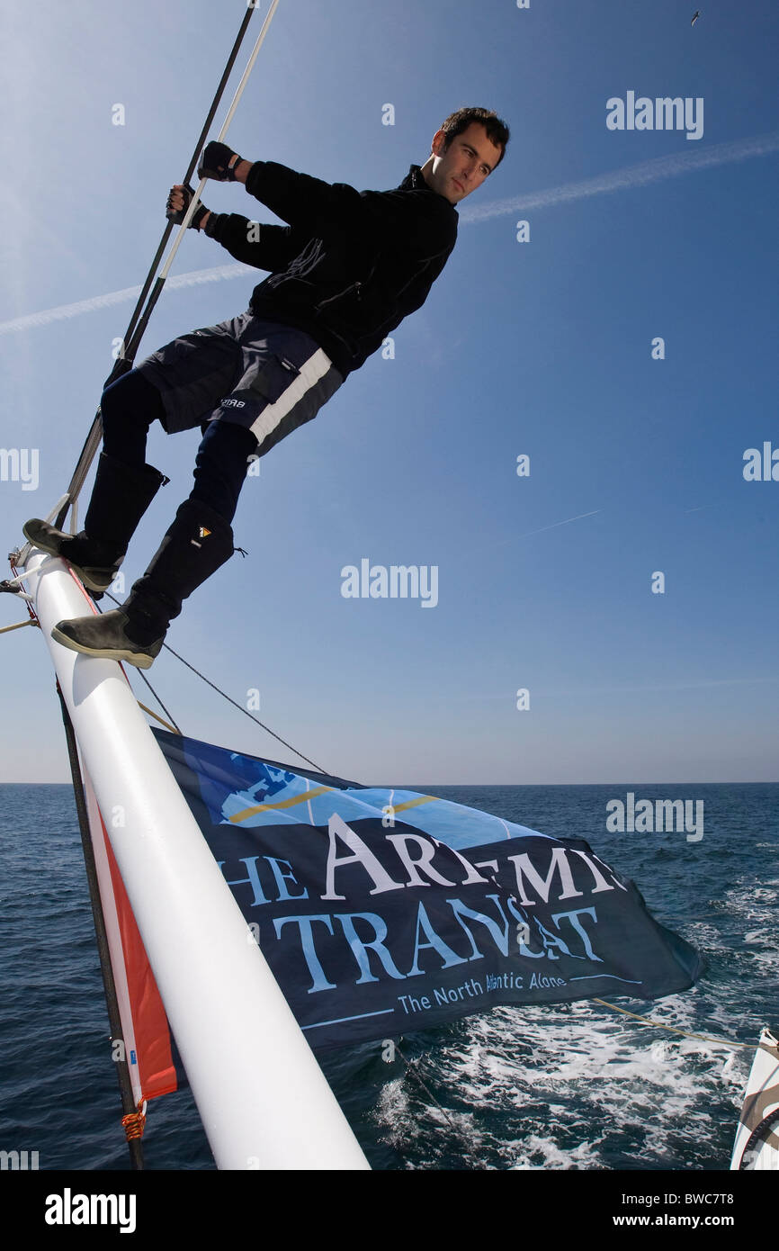 Skipper Armel le Cleac'h standing on boom of Monohull Imoca 60ft "Brit ...