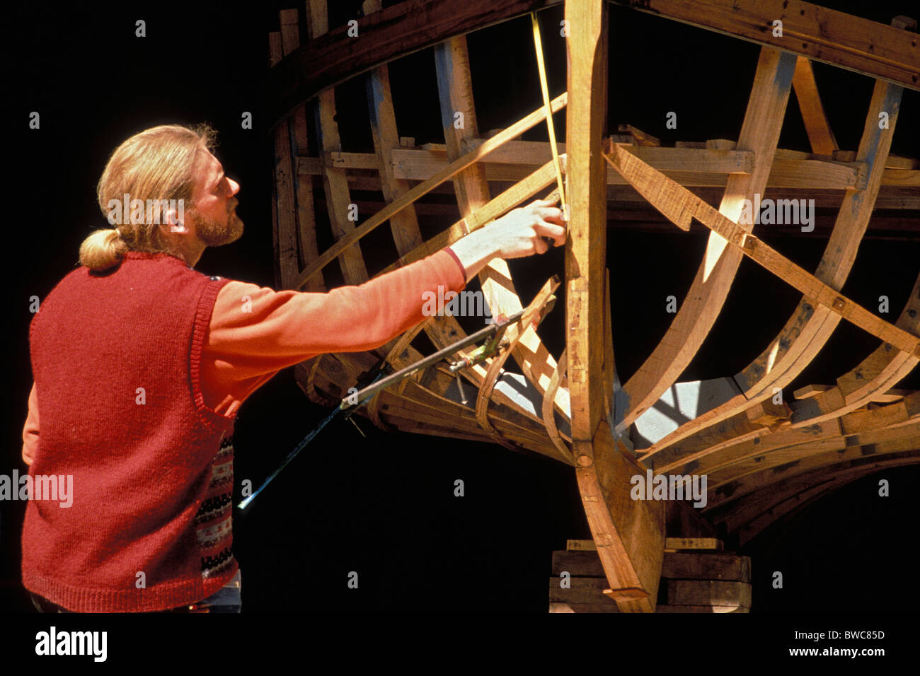 Marine carpenter working on the hull of a boat in Ateliers de l`Enfer ...