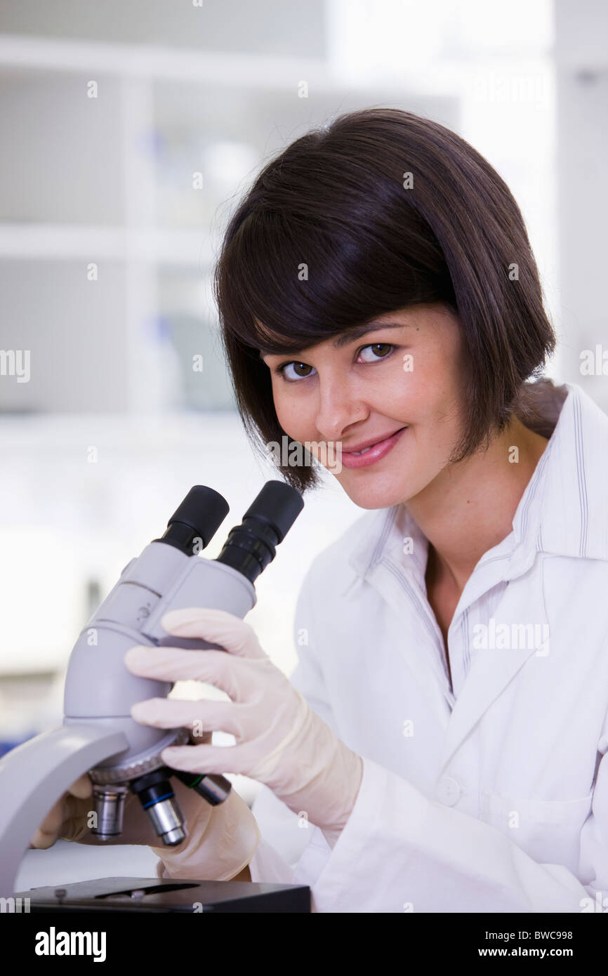 Female scientist using microscope in laboratory, portrait Stock Photo ...