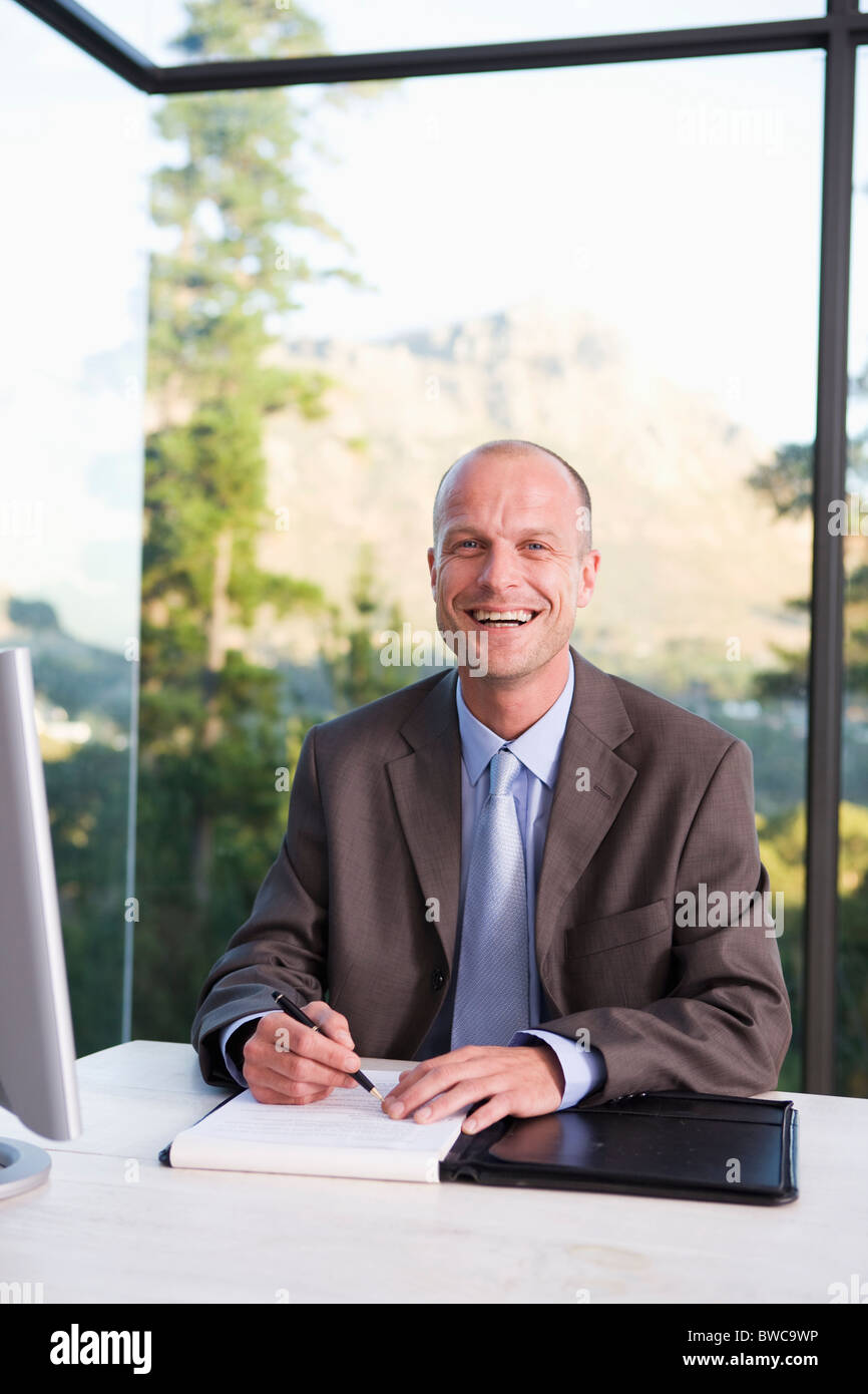 Portrait of mid adult businessman signing document, smiling Stock Photo ...