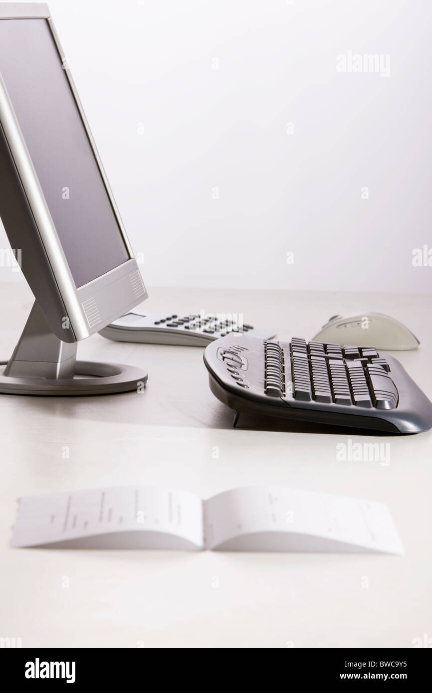 Computer and bill on office desk Stock Photo - Alamy