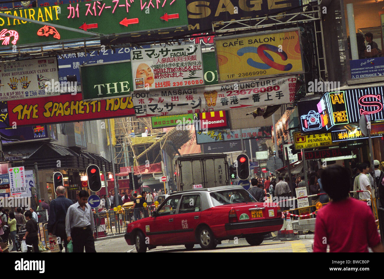Kowloon district, with neon signs, advertising and a red taxi in Hong ...