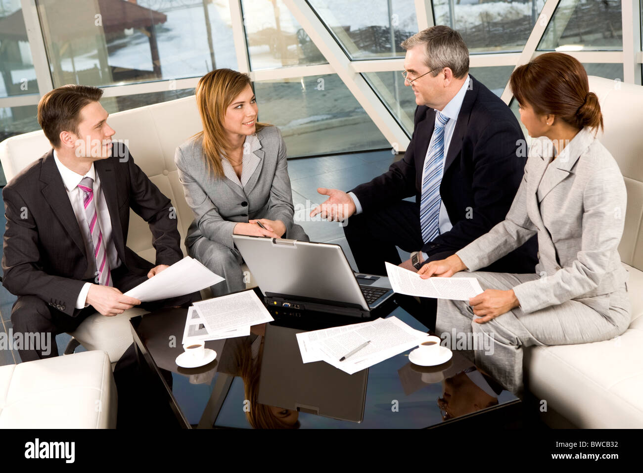 Portrait of confident business partners communicating in office at ...