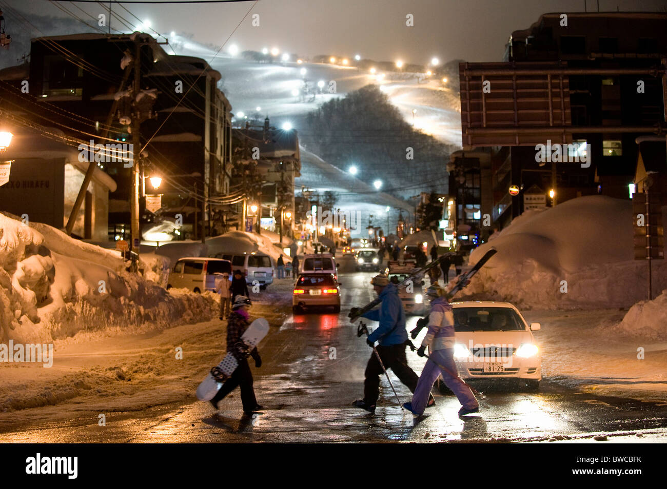 The lights of Grand Hirafu ski resort in the distance, boarders and ...
