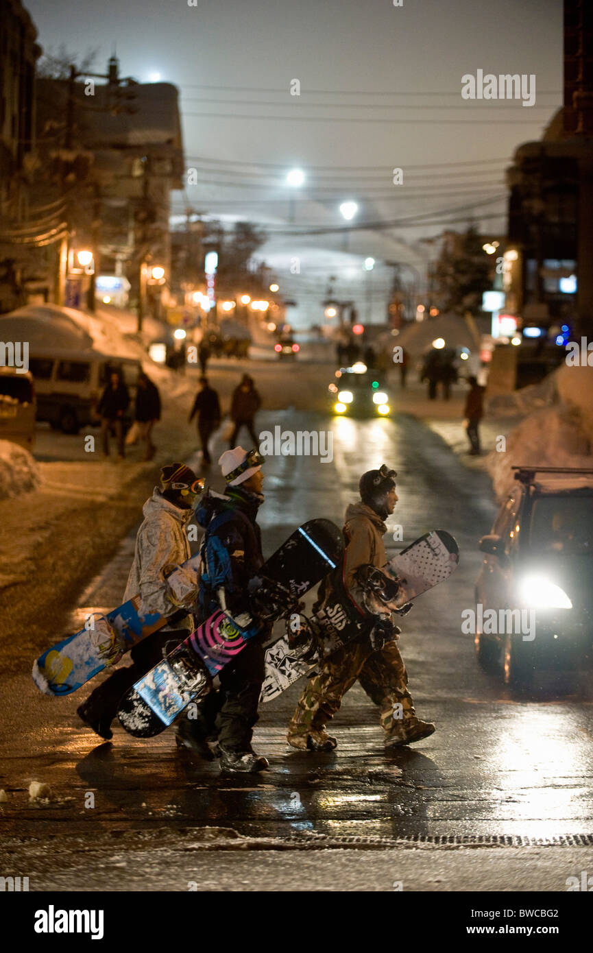 The lights of Grand Hirafu ski resort in the distance, boarders and ...