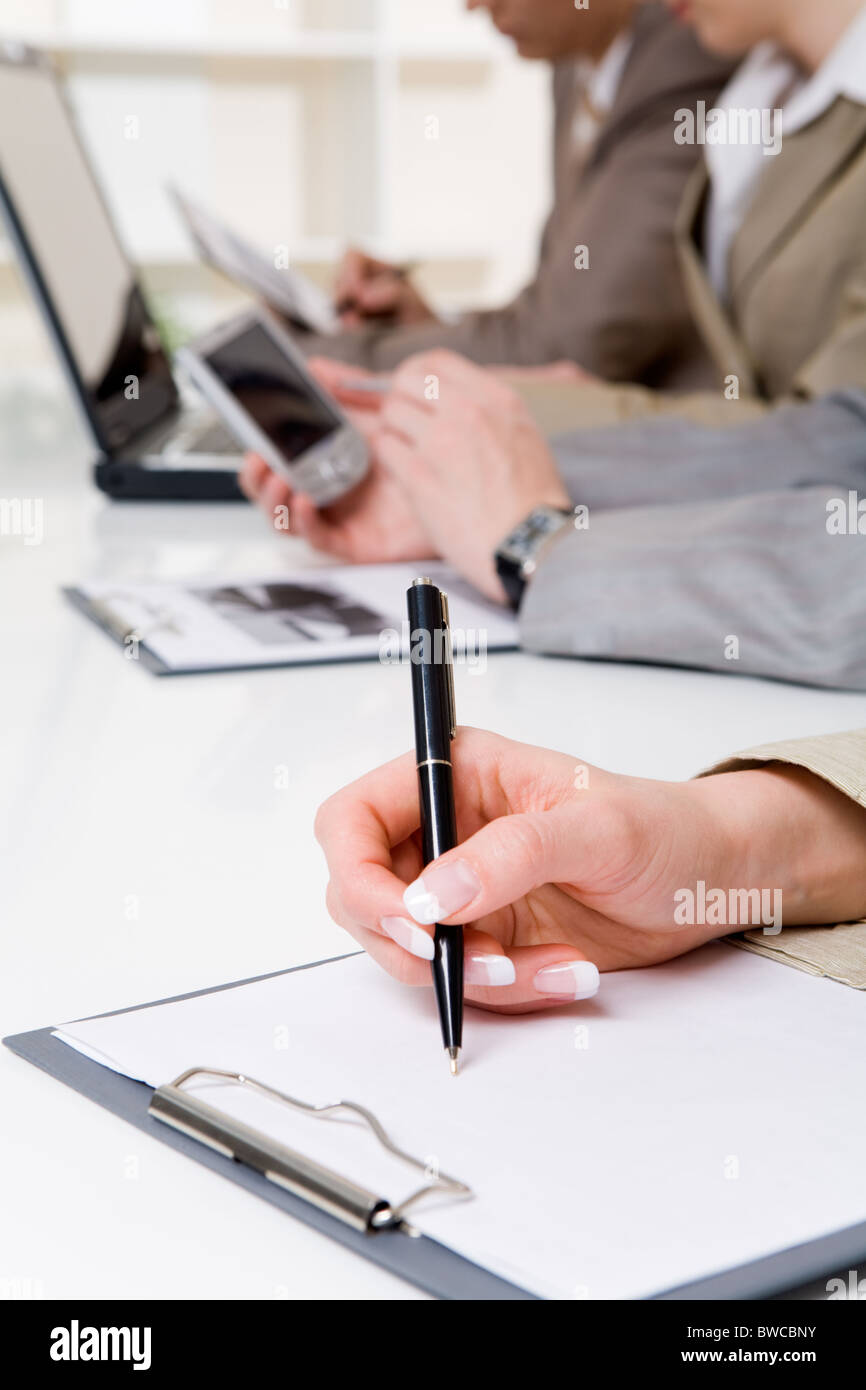Image of female hand with ballpoint writing on paper on background of ...