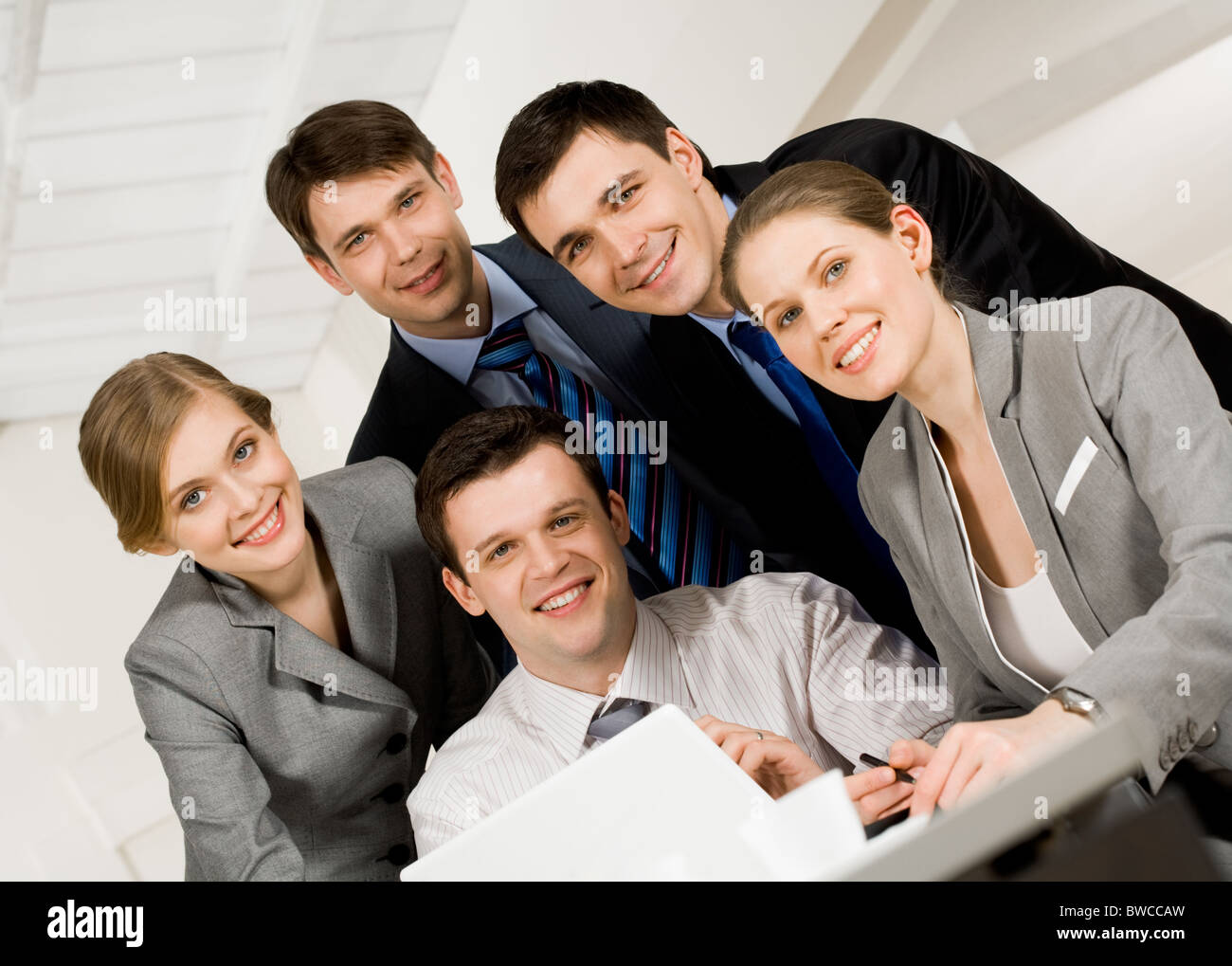 Portrait of several successful employees looking at camera and smiling ...