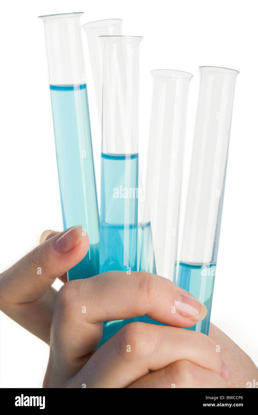 Close-up of human hand holding glass tubes with blue liquid inside them ...
