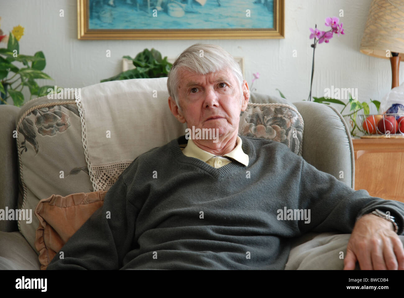 OAP man sitting in a chair in his living room Stock Photo - Alamy