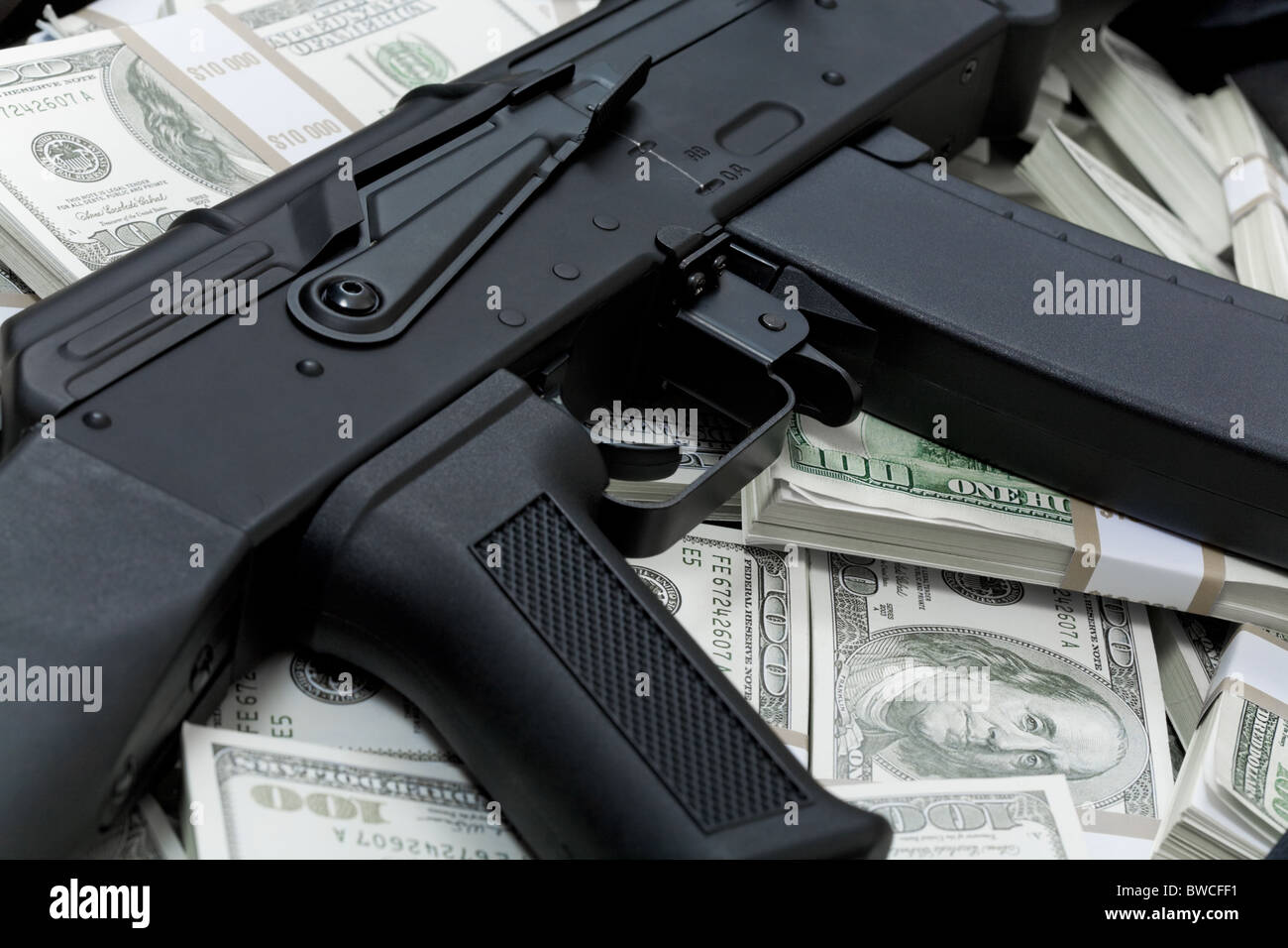 Close-up of black weapon lying on heap of hundred dollar bills Stock ...