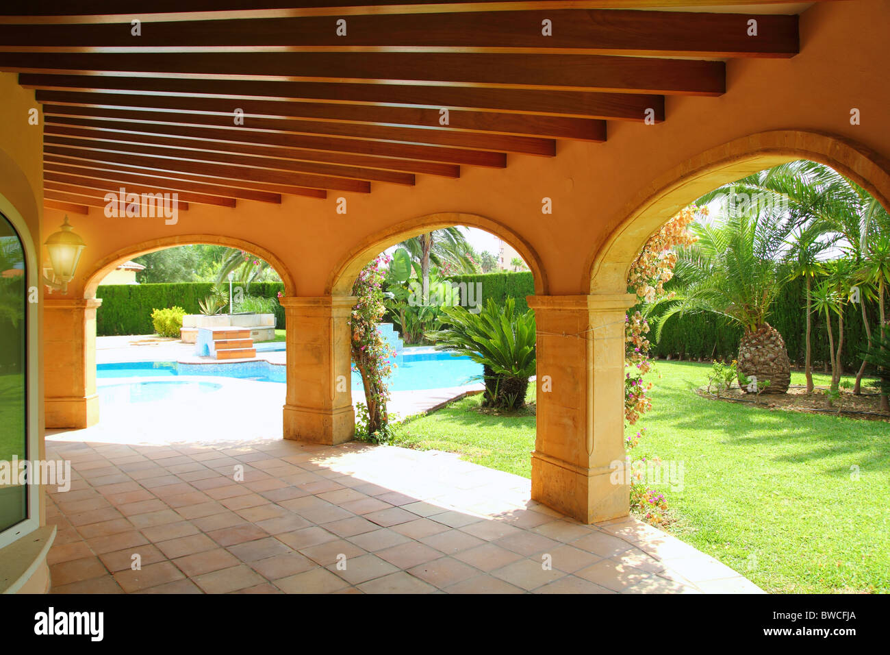 colonnade arch house in yellow on blue swimming pool garden Stock Photo ...