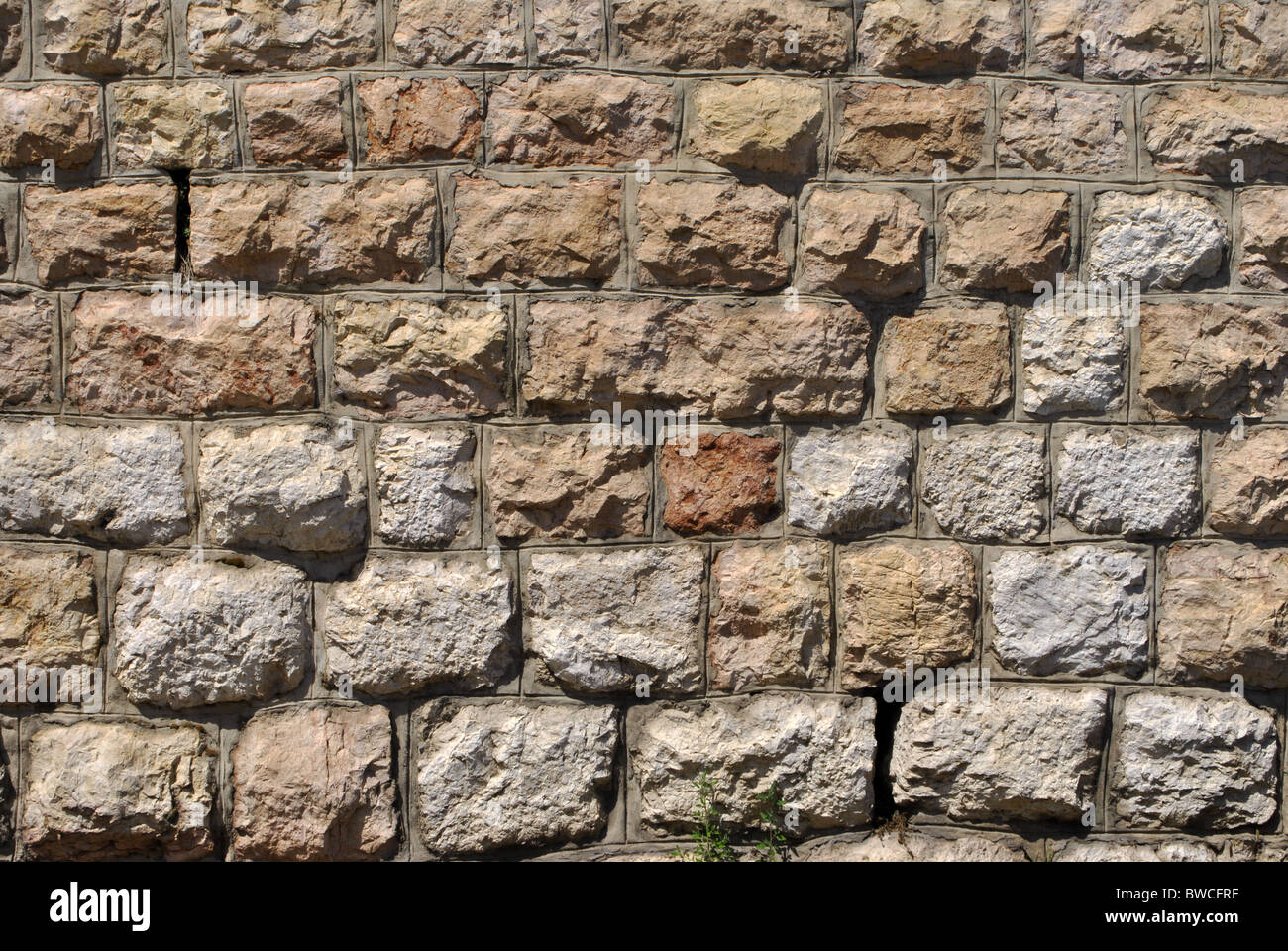 regular wall built with stones and colorful Stock Photo - Alamy