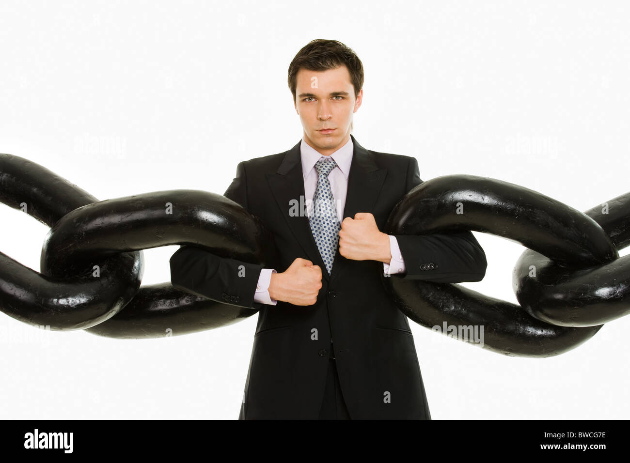 Portrait of powerful businessman with several sections of huge chain ...