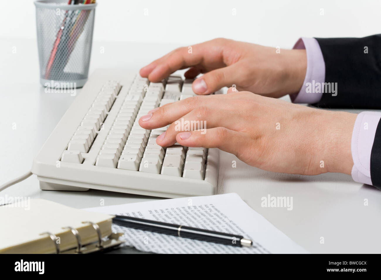 Close-up of male hands pressing keys of computer board on workplace ...