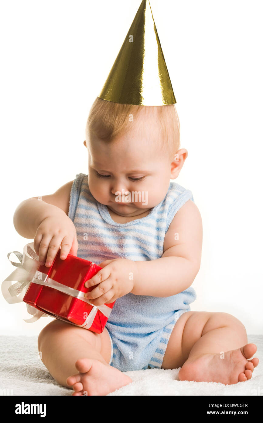 Photo of adorable baby holding birthday present in hands Stock Photo ...